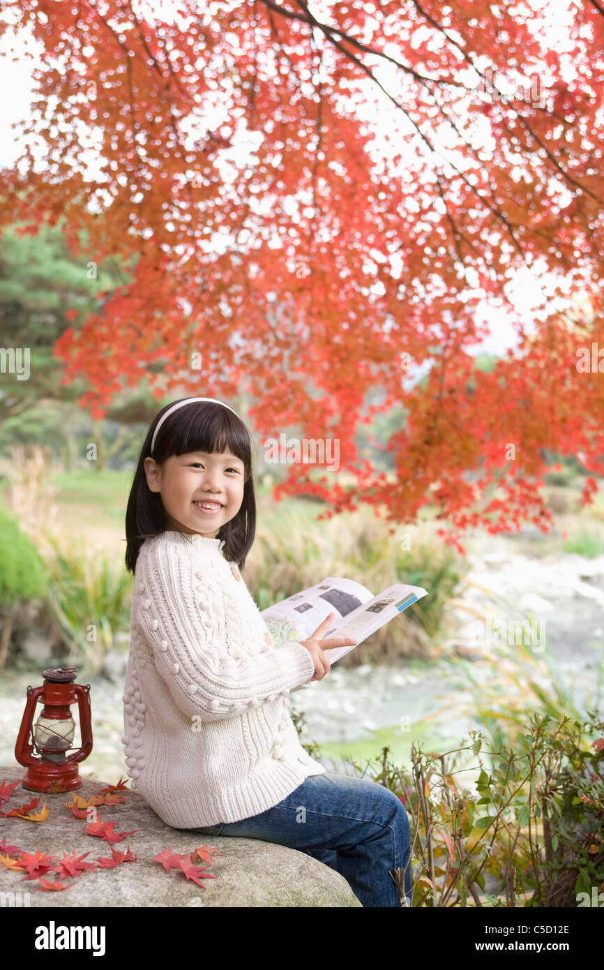 girl reading a book under the autumn trees Stock Photo - Alamy