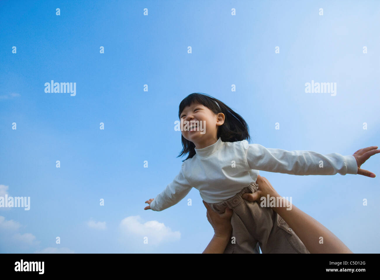 someone's arms rasing girls to the sky Stock Photo - Alamy