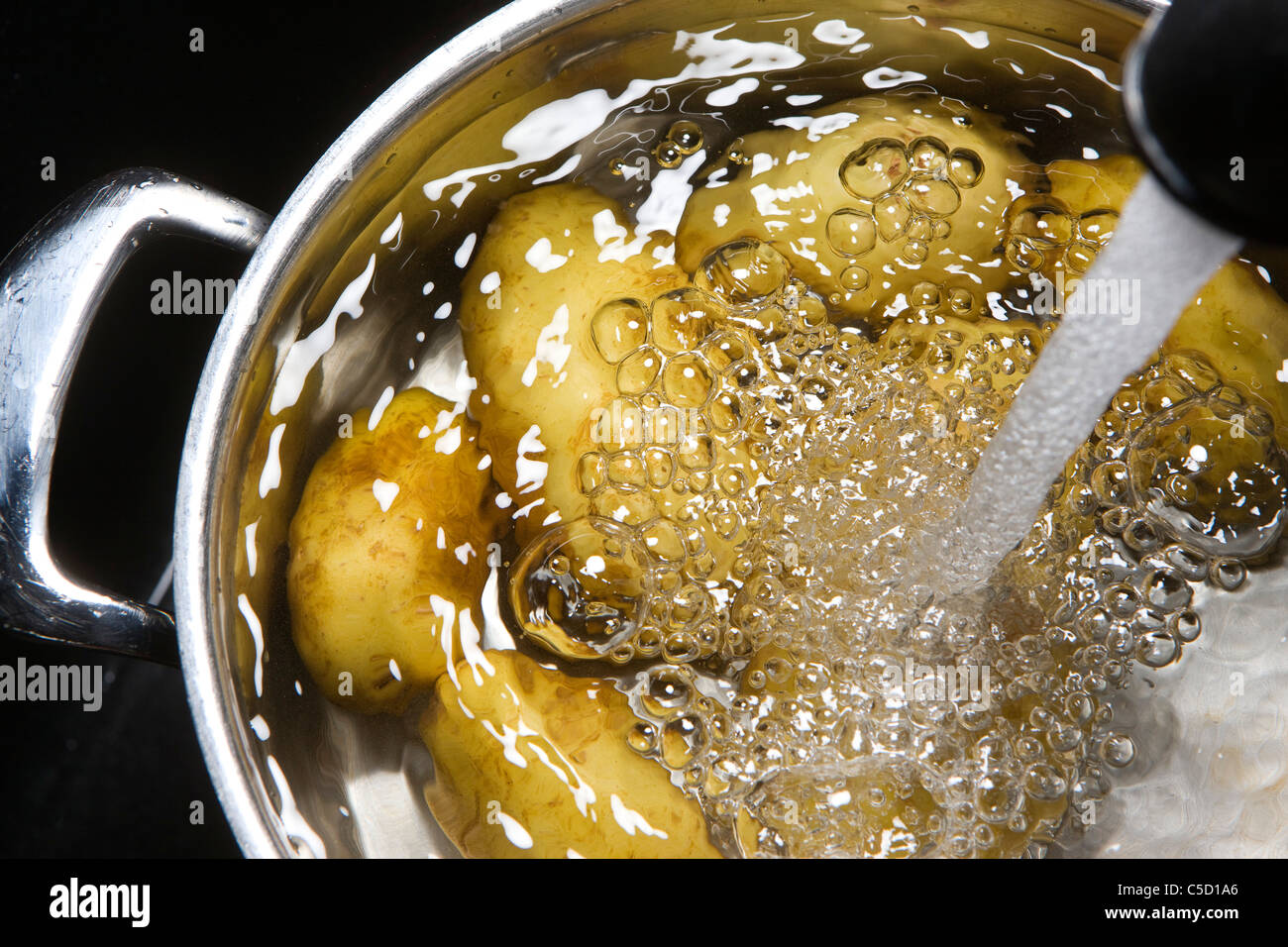 Water pouring on unpealed potatoes for cooking Stock Photo - Alamy