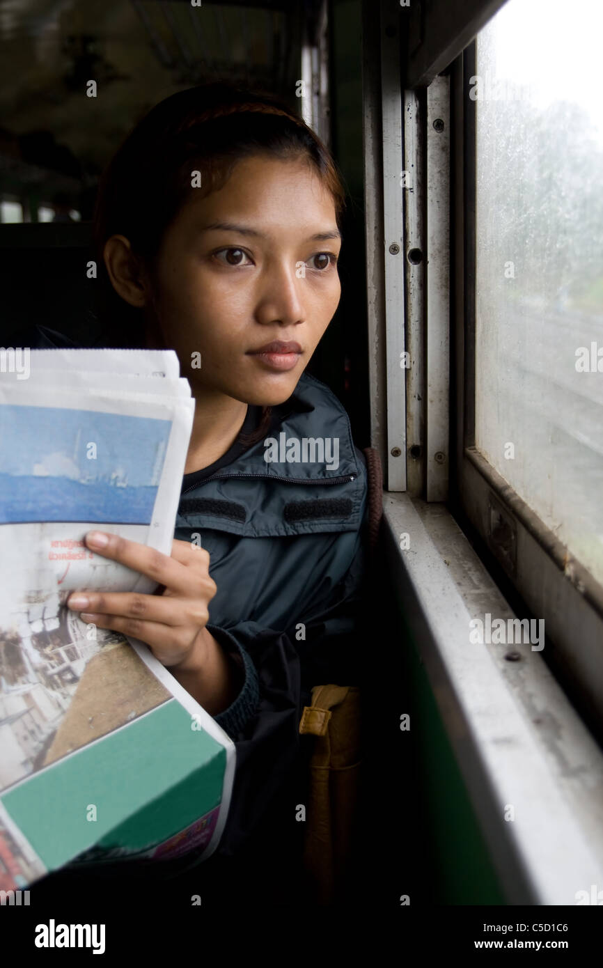 Young woman reading a newspaper on a train Stock Photo - Alamy