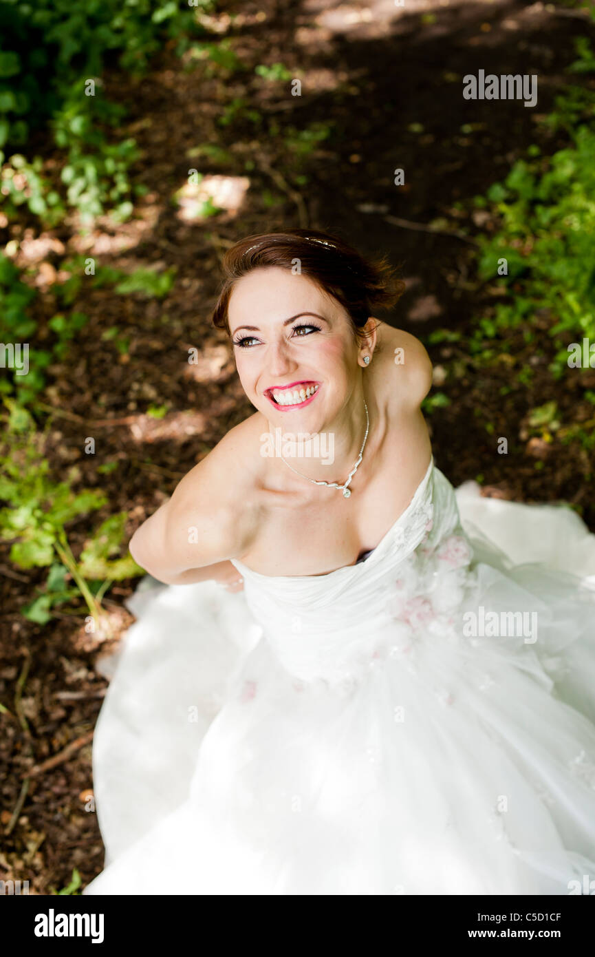 Bride smiles and has fun in wedding dress outside Stock Photo - Alamy