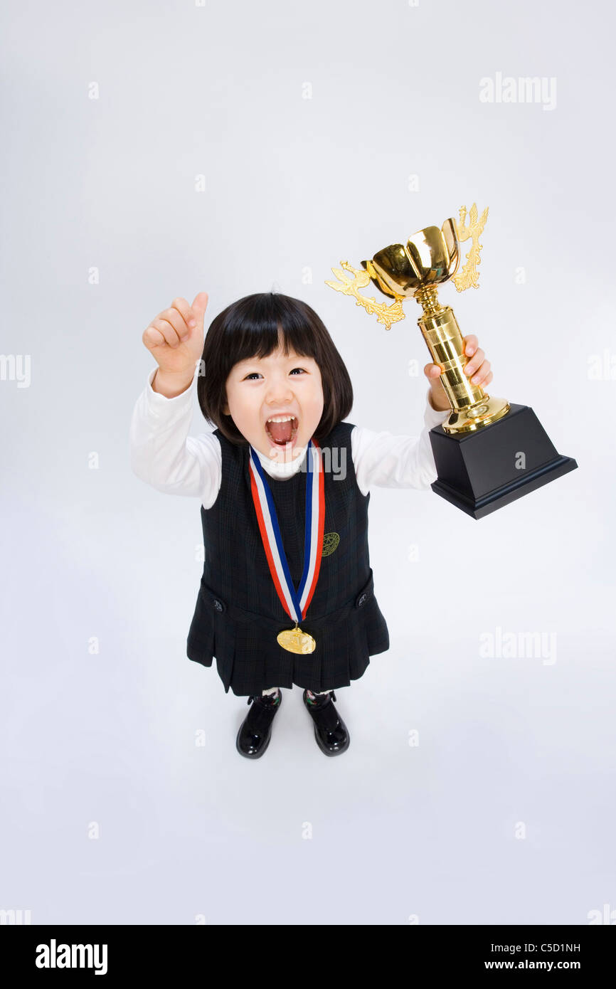 girl smiles raising her trophy Stock Photo - Alamy