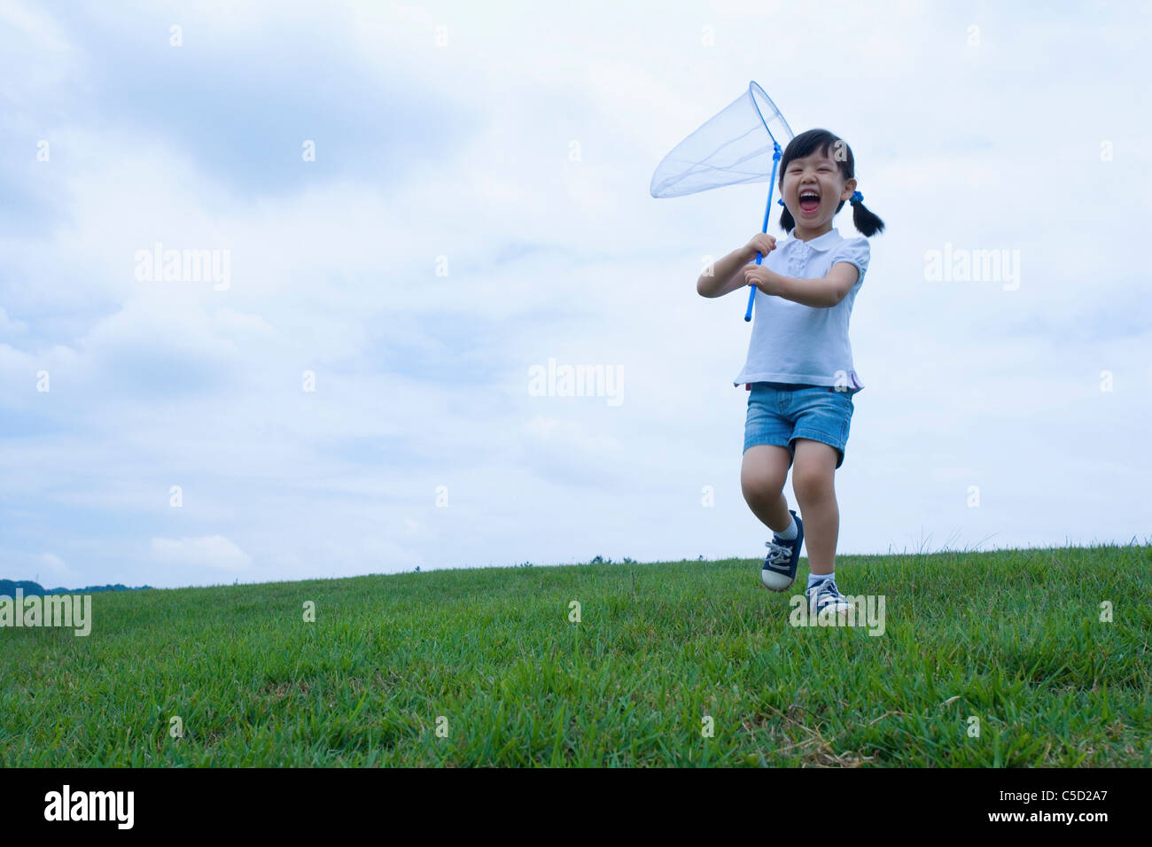 girl walking through the field holding dragonfly net Stock Photo - Alamy