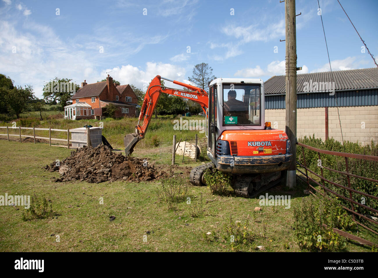 Kubota digger digging trench for electric ducting Cotswolds UK Stock ...