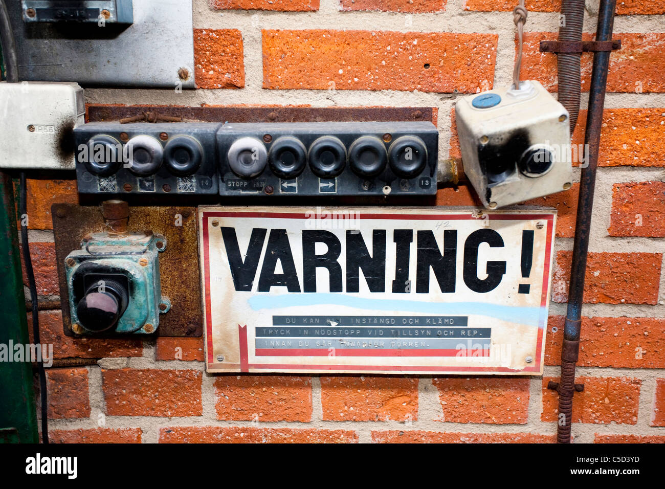 Close-up of an old warning sign and actuator on brick wall Stock Photo ...