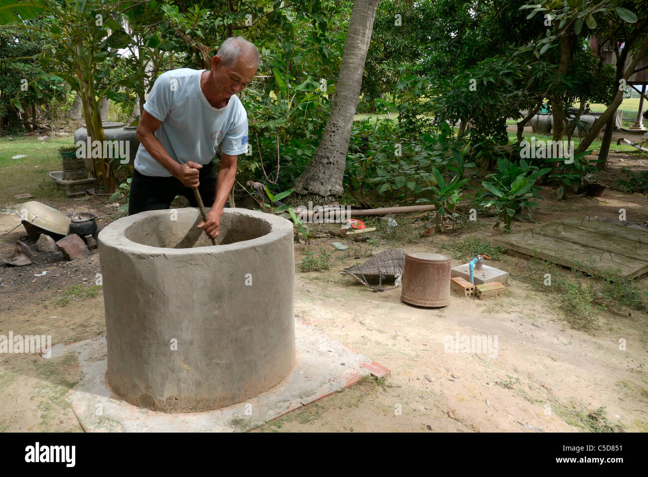 CAMBODIA Mixing cow dung in bio-gas generator Stock Photo - Alamy