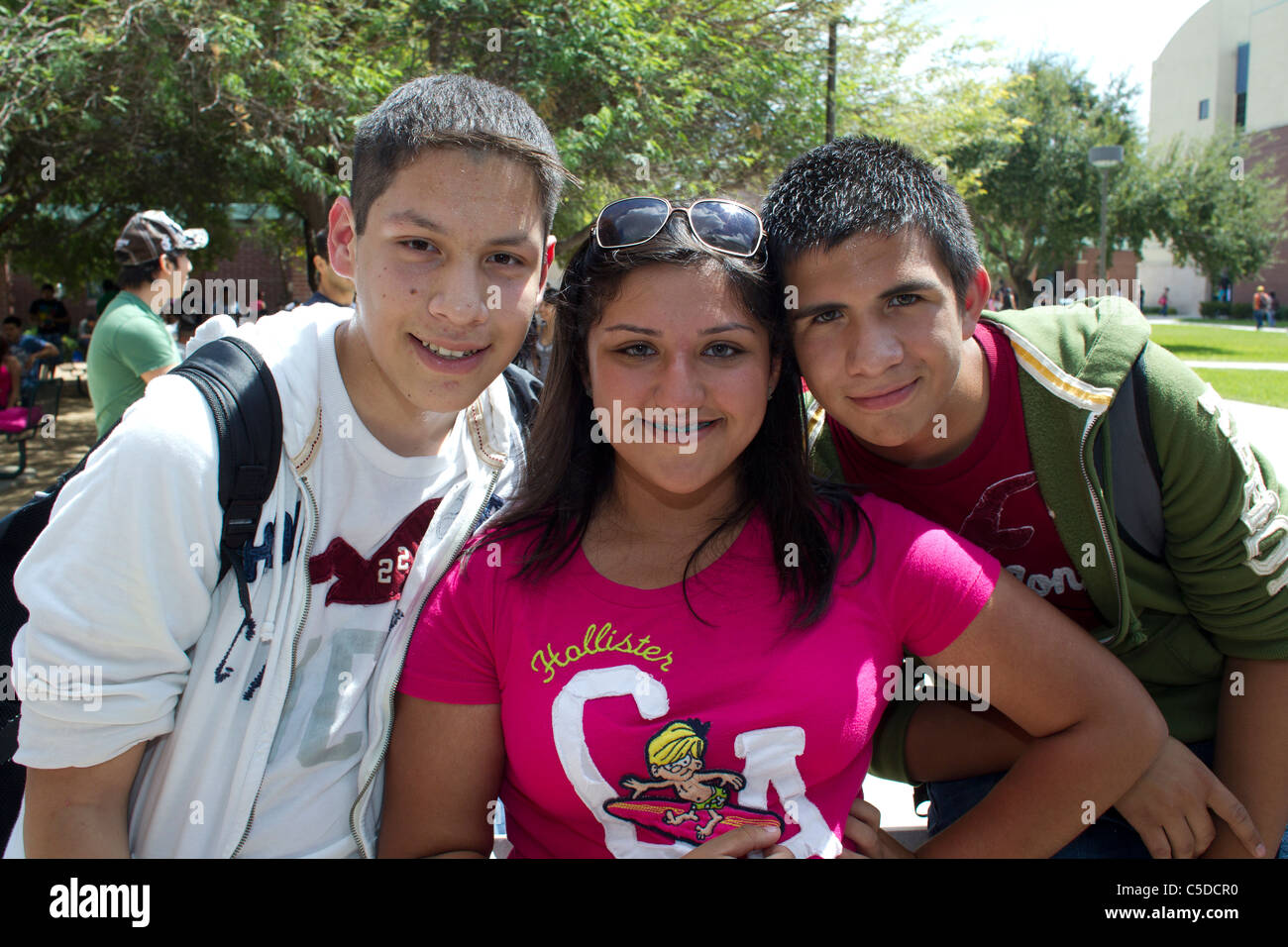 Group of smiling Hispanic students pose for a photograph in between ...