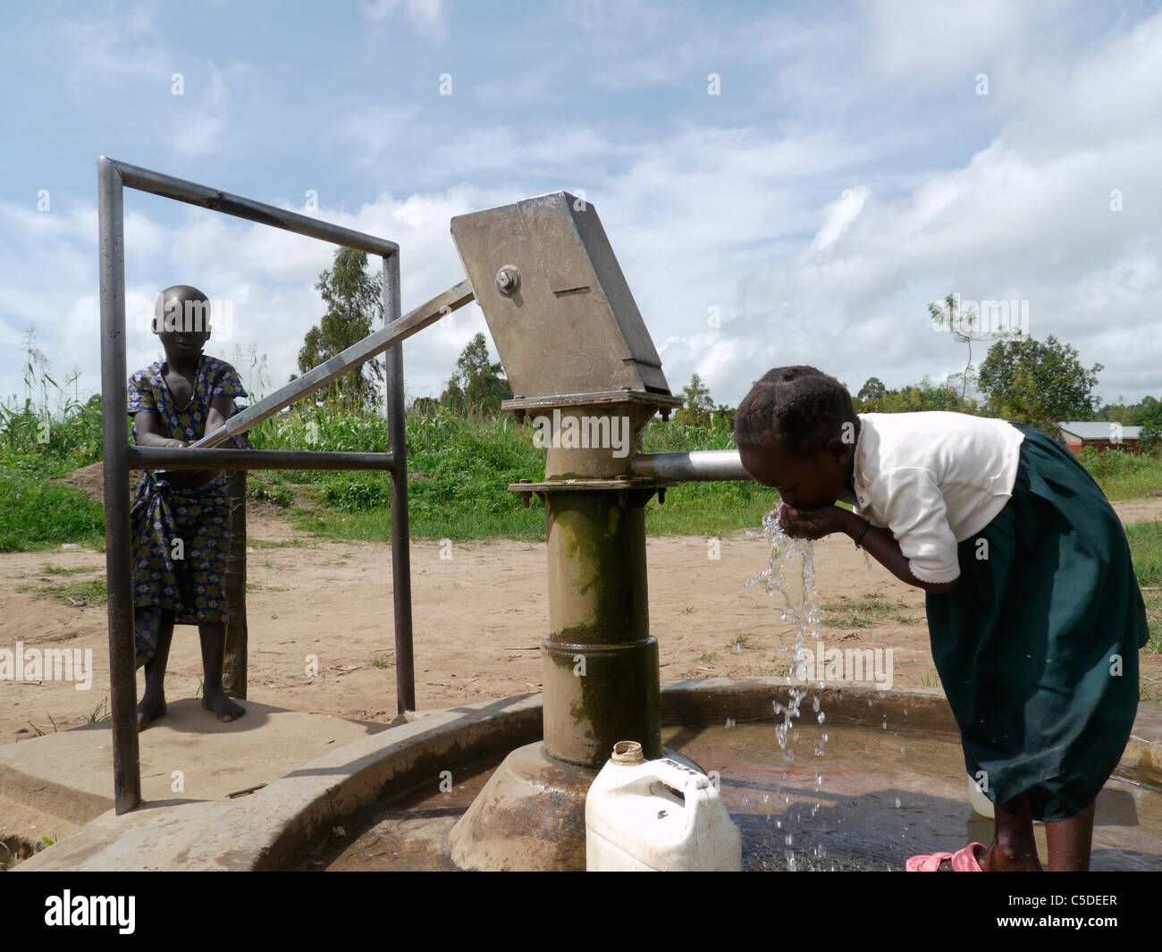 UGANDA Children collecting water from hand-pumped bore well, Gulu ...