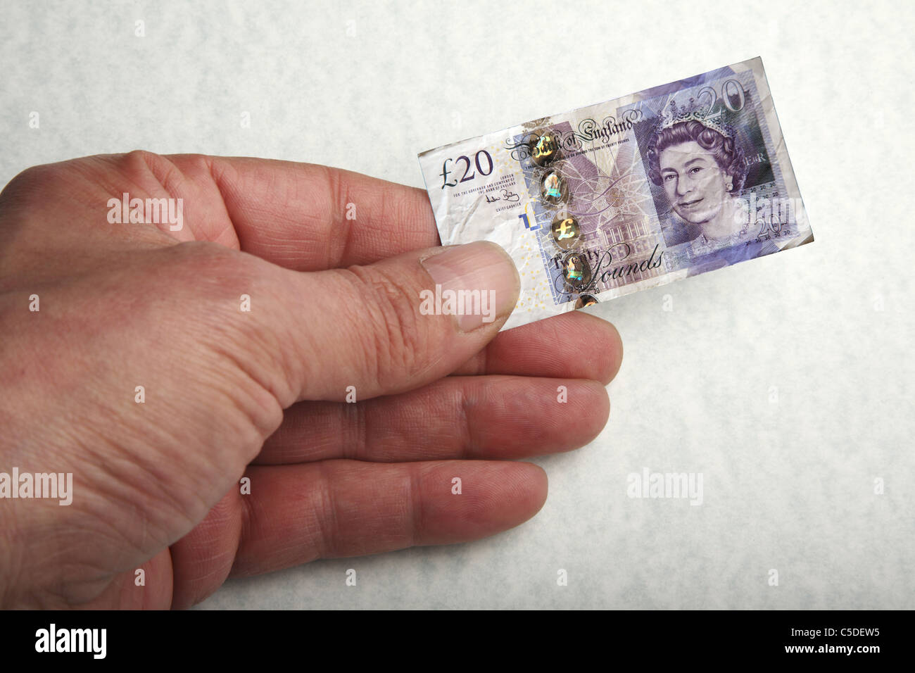 Hand holding shrunken twenty pound note Stock Photo - Alamy