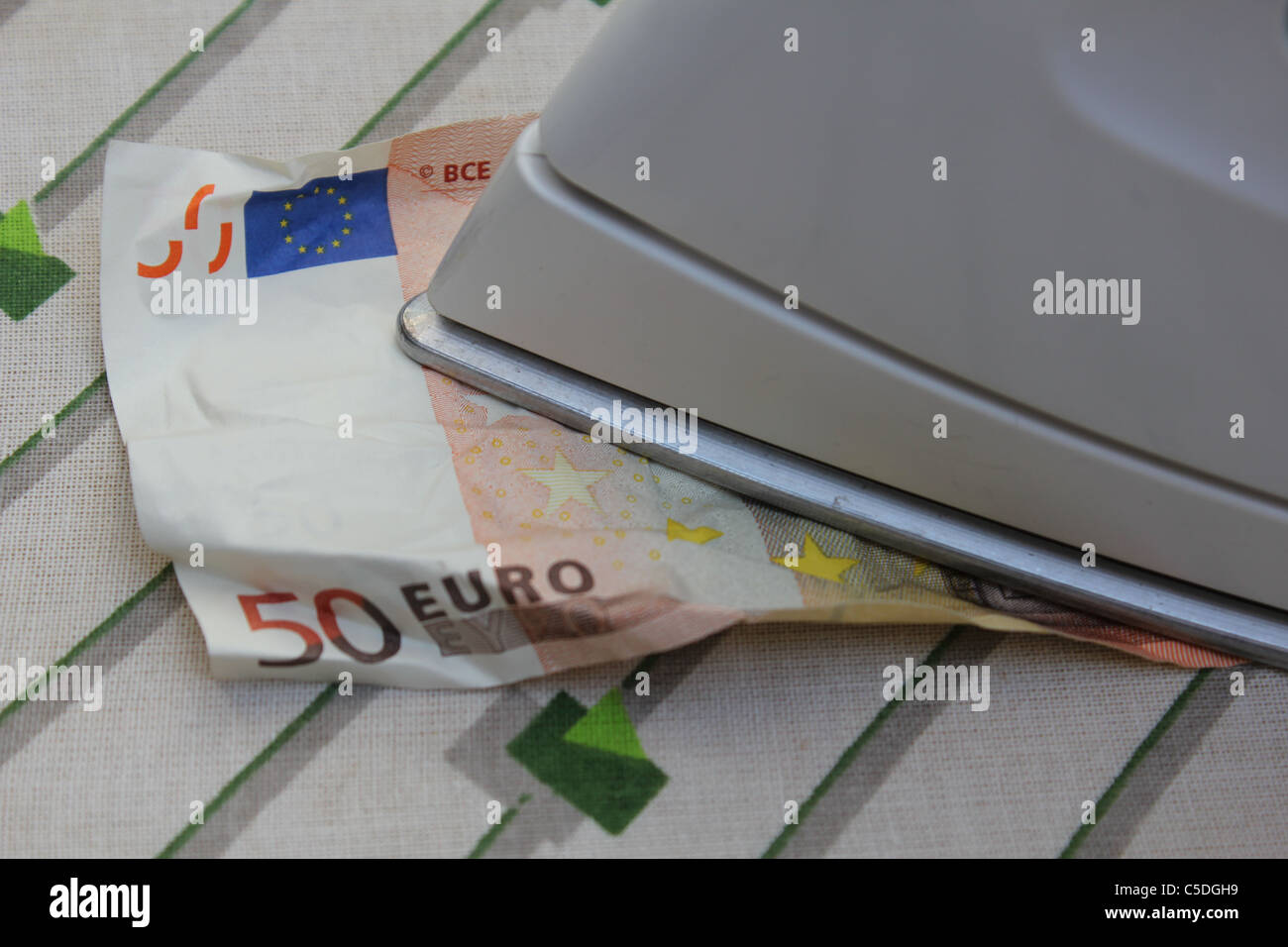 smoothing a crumpled 50 euro note with a flatiron Stock Photo - Alamy