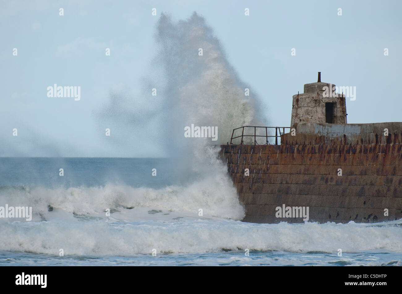 Wave breaking against a wall Stock Photo - Alamy