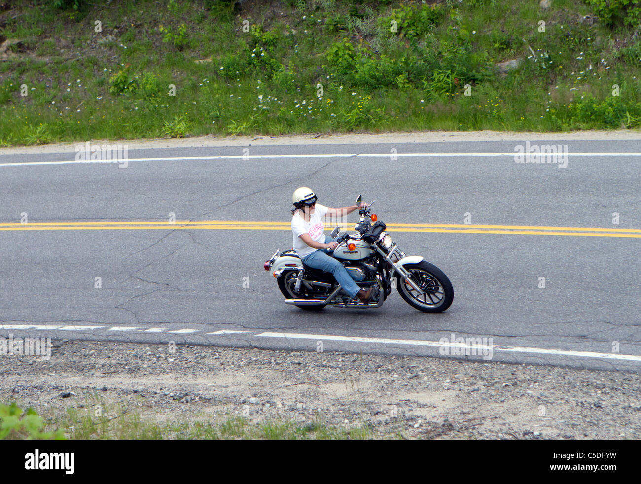 A woman riding a Harley Davidson motorcycle motorbike on a mountain ...