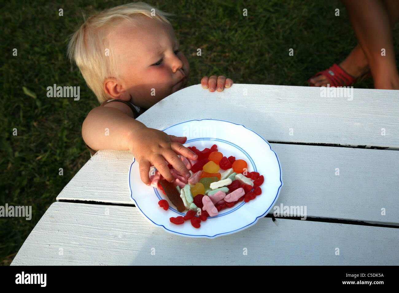 Child take sweets hi-res stock photography and images - Alamy