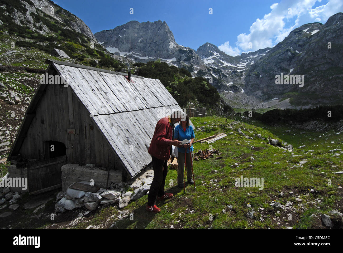 Farmer at Katun lovice studies with hiker map, Durmitor NP. Montenegro ...