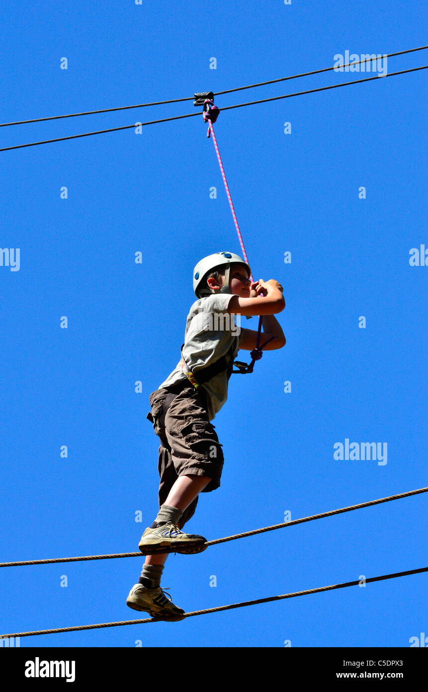 Boy crossing a high rope bridge Stock Photo - Alamy