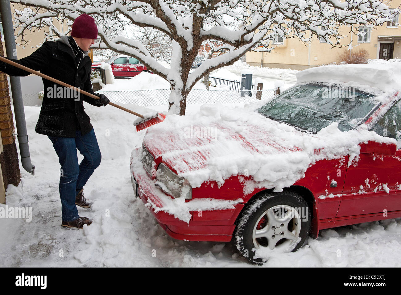 Full length side view of a man cleaning snow off his car Stock Photo ...