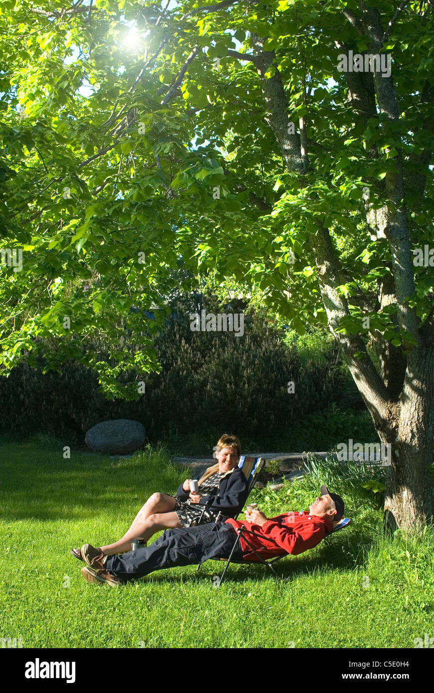 Couple lying on grass under tree hi-res stock photography and images ...