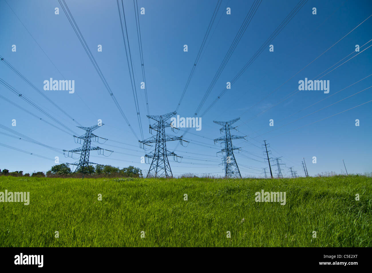 A long line of electrical transmission towers carrying high voltage ...