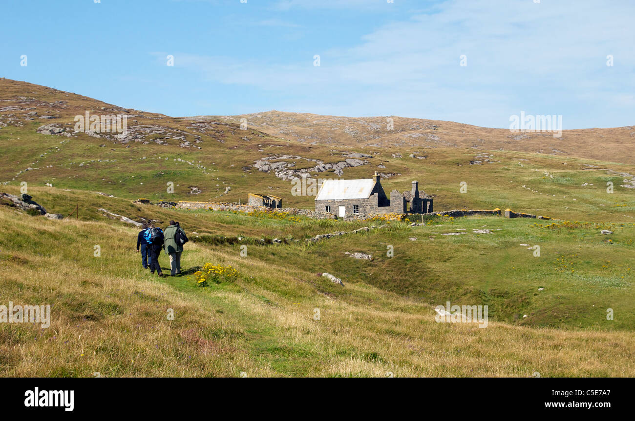 Walkers approach the Old School House on the deserted island of ...