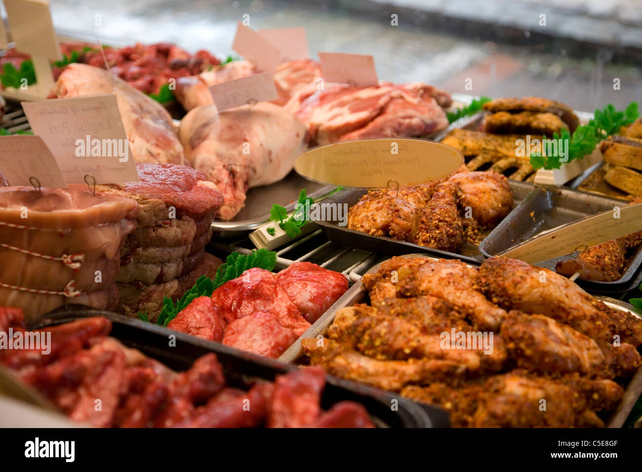 Meats on display in butcher shop window Stock Photo - Alamy