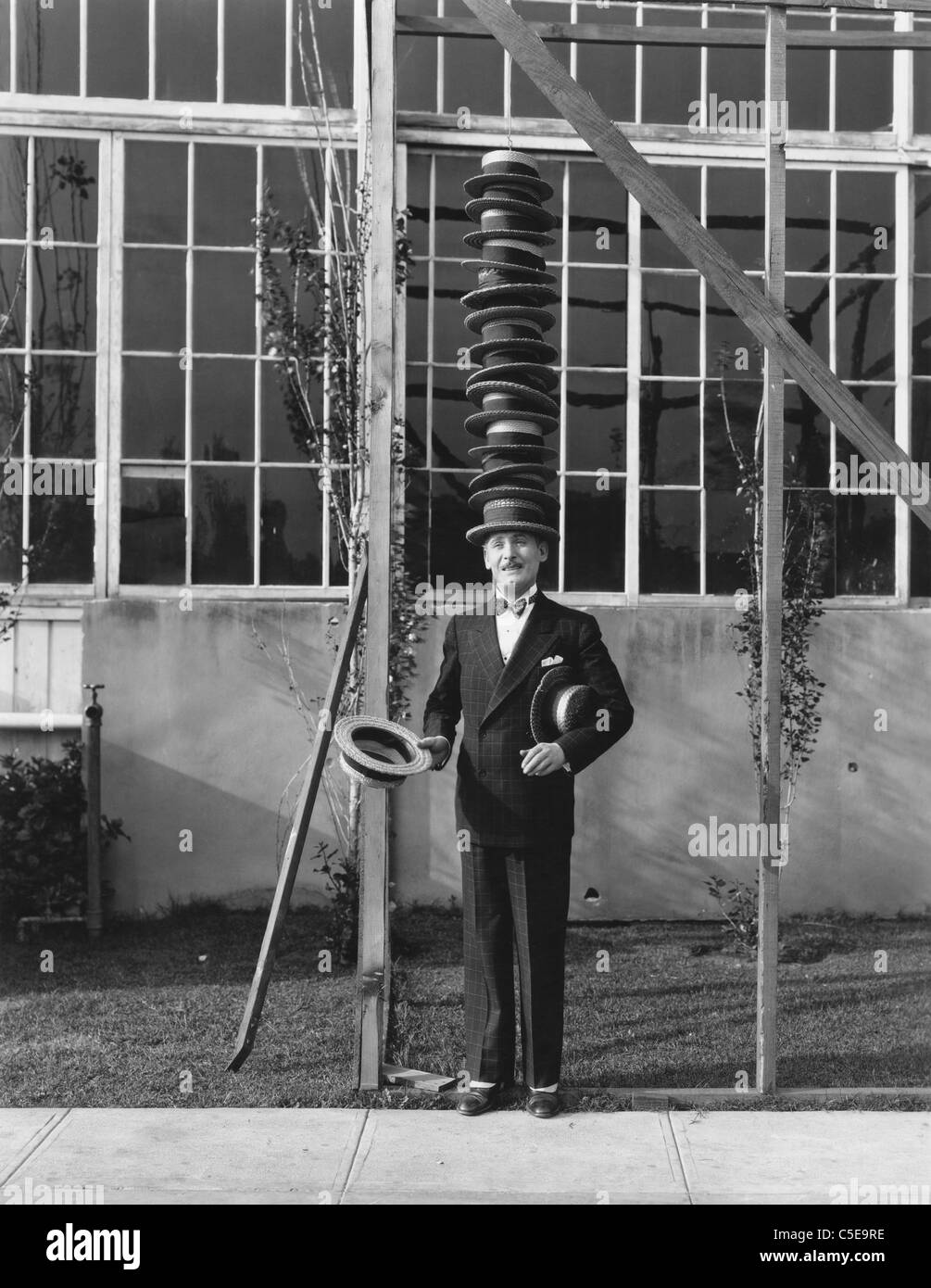 Man standing with stack of hats on head Stock Photo - Alamy