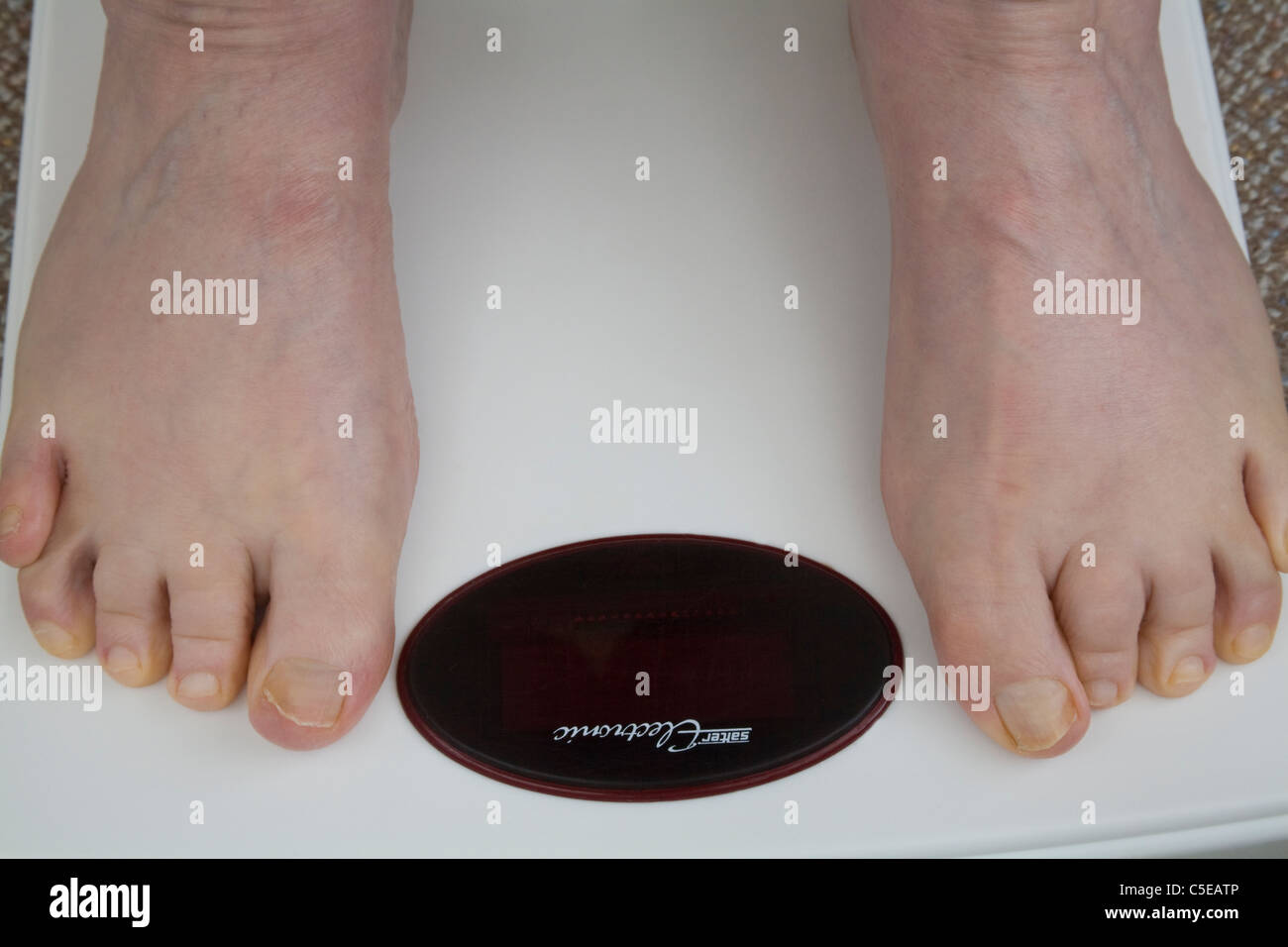 Pair of woman's feet weighing on electronic scales Stock Photo - Alamy