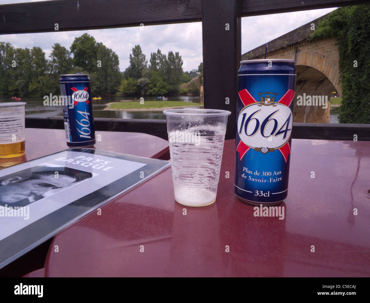 Cans of 1664 Kronenbourg lager beer with a menu, on a table in a snack ...
