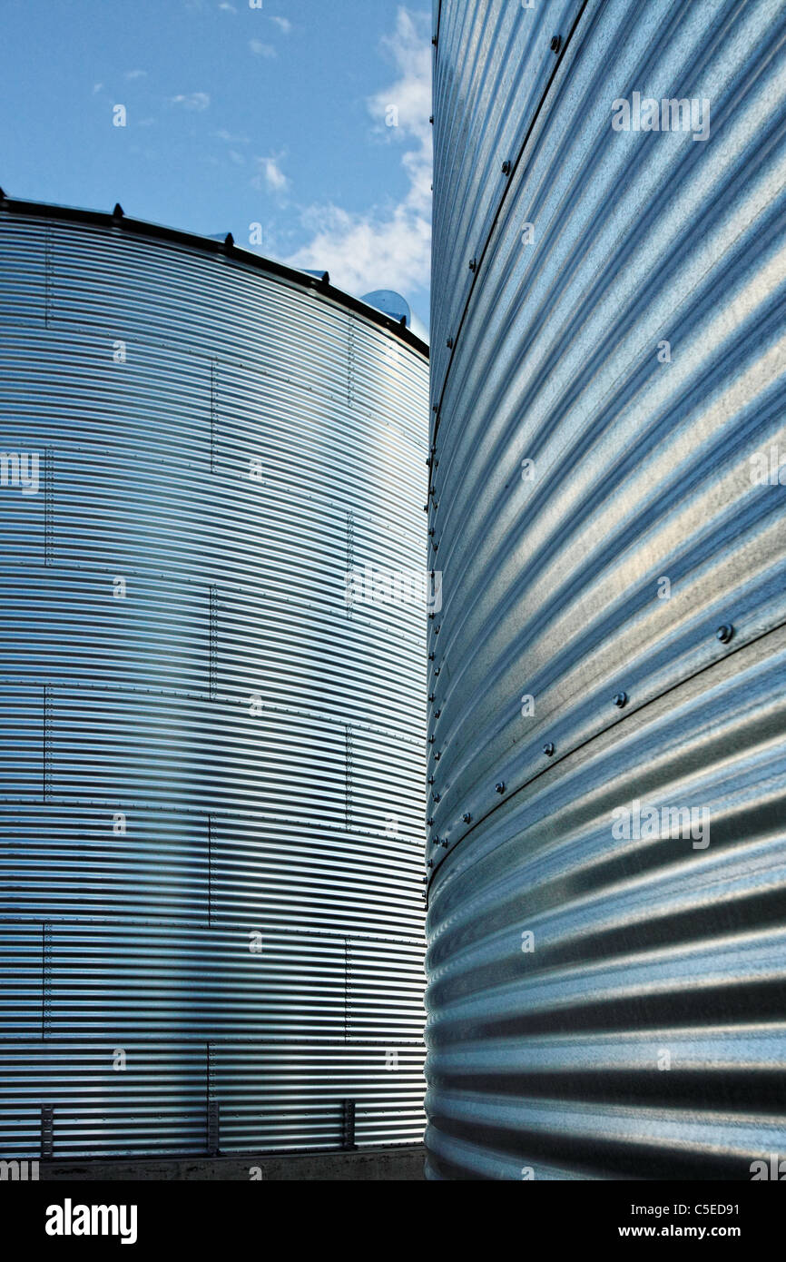 Blue sky reflected in shiny new grain storage silos Stock Photo - Alamy