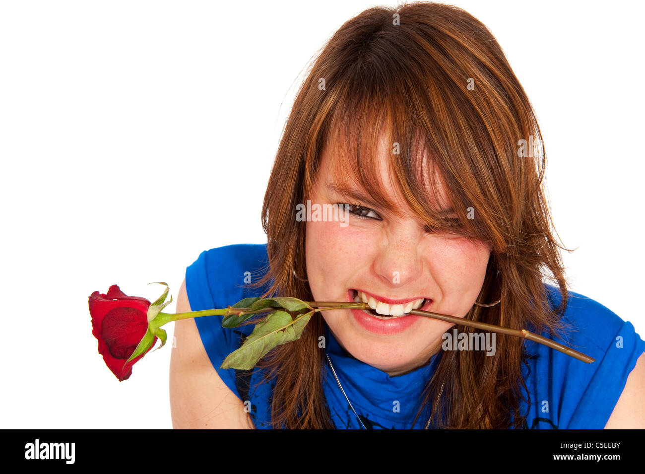 Angry young woamn with rose in het mouth Stock Photo - Alamy