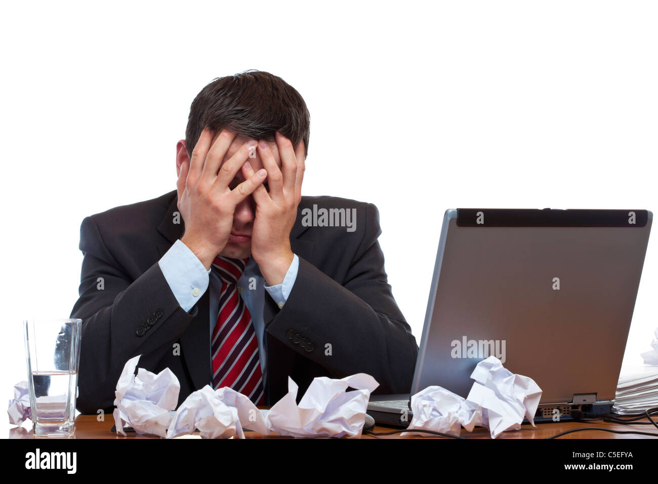Frustrated man sitting desperate over paper work at desk. Isolated on ...