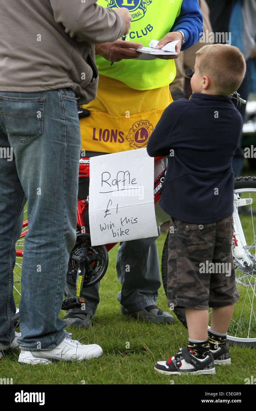 A young boy pictured with his dad playing a raffle in a park in ...