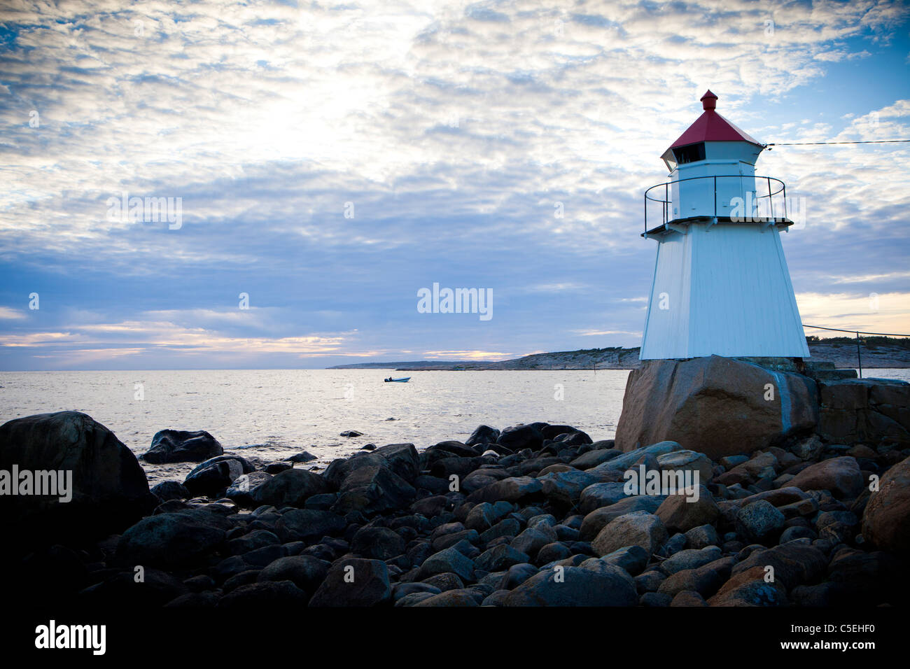 Lighthouse on rocky beach Stock Photo - Alamy