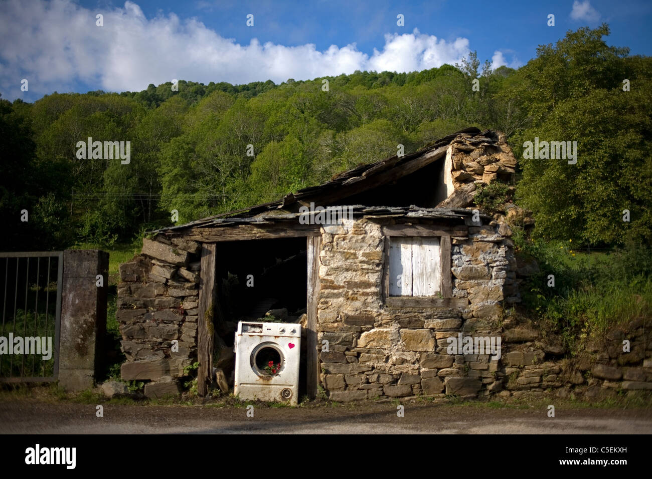 A broken washing machine blocks the door of an abandoned house located ...