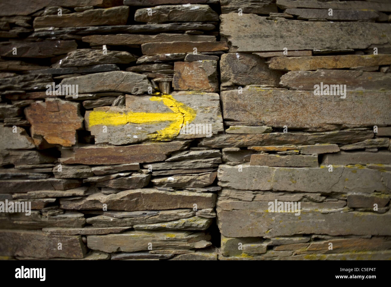 A yellow arrow is painted in a house to guide pilgrims in the French ...