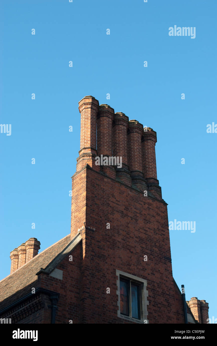 Row of five brick domestic chimneys on gable end of old building ...