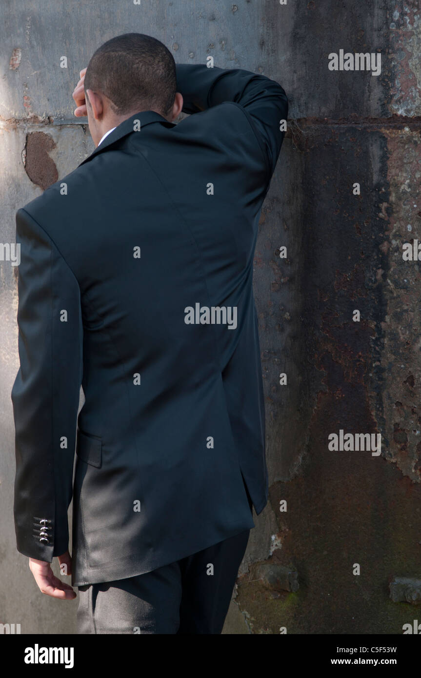 Depressed businessman man standing against the wall Stock Photo - Alamy