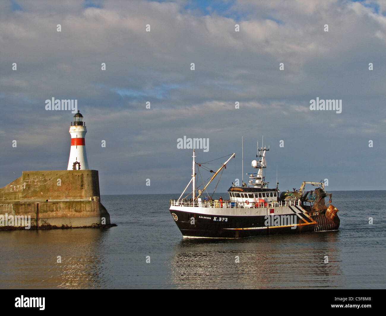 Fishing boat entering port Stock Photo - Alamy