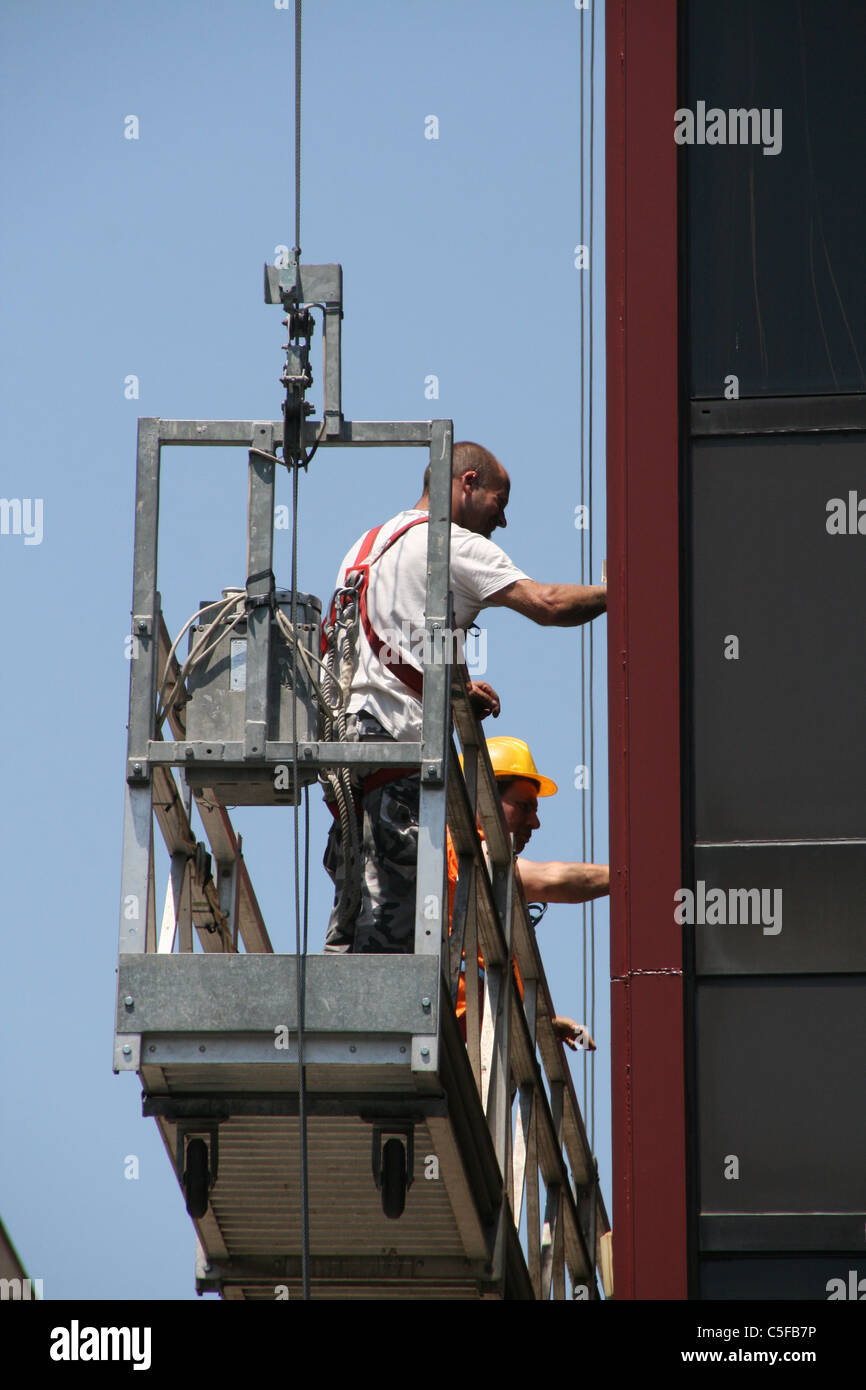 men on a lift cleaning windows of office block Stock Photo - Alamy