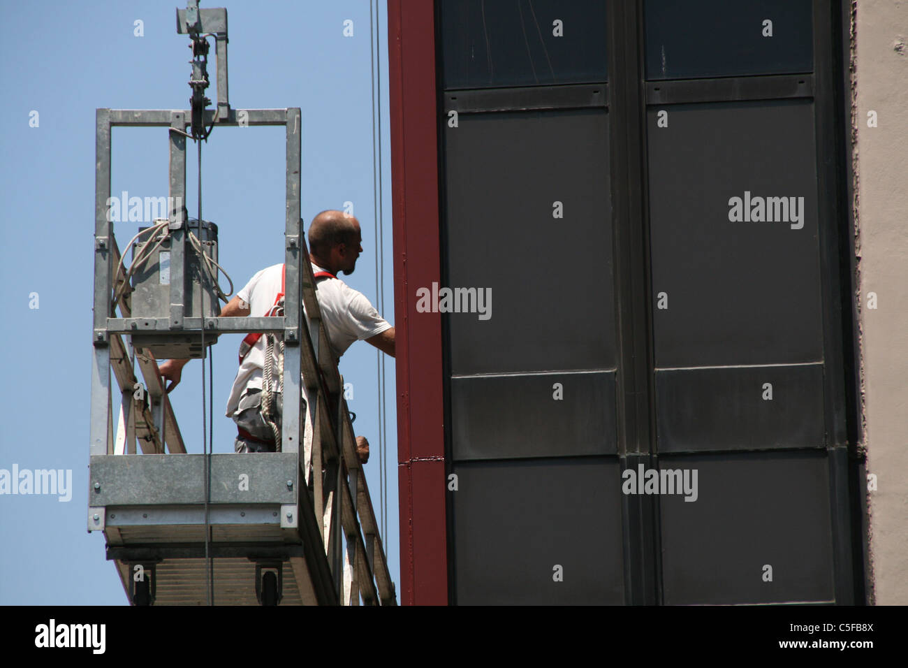 men on a lift cleaning windows of office block Stock Photo - Alamy