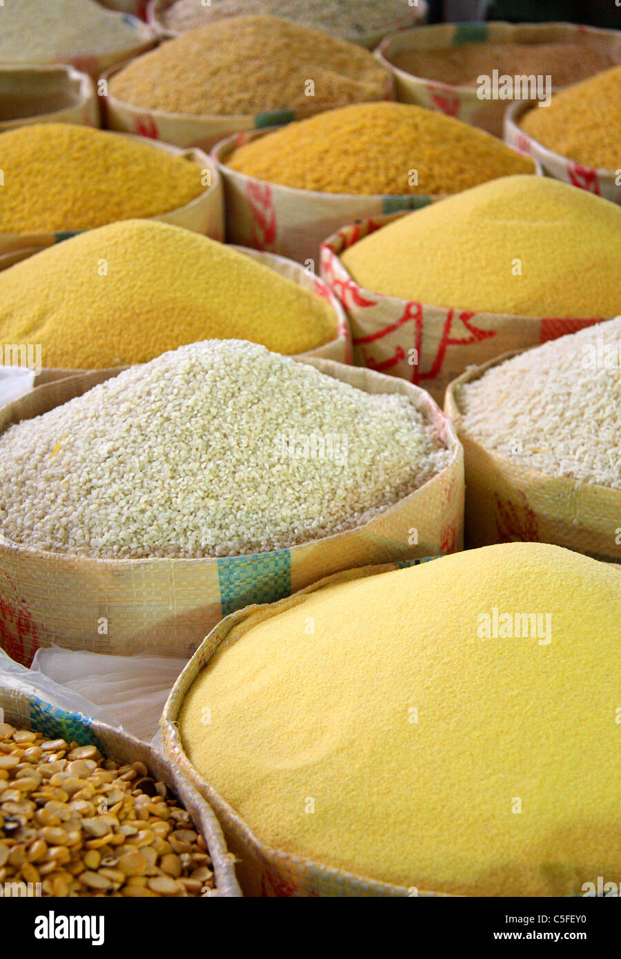 Grains, including couscous, presented in sacks for sale on a stall in a ...