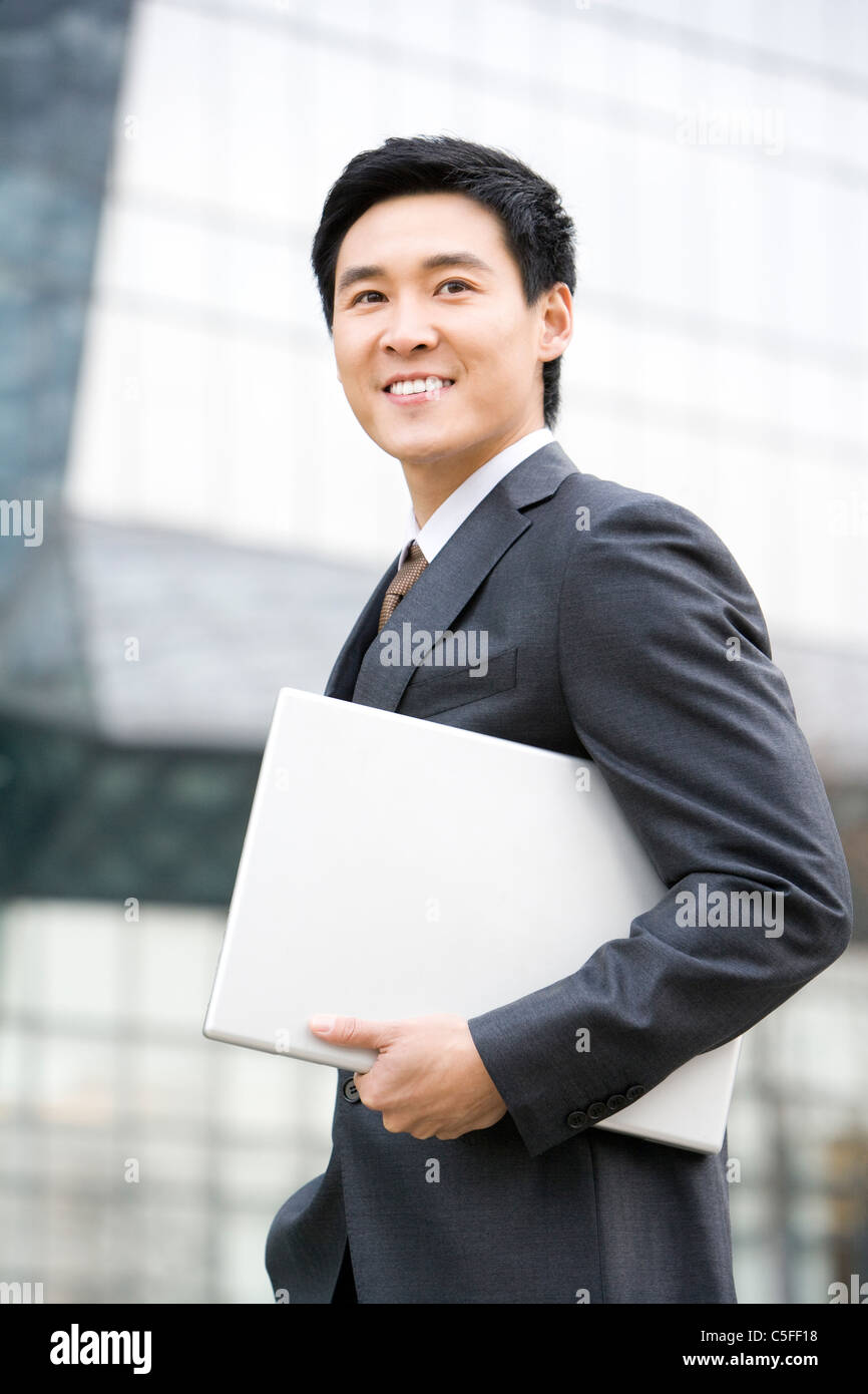 Businessman holding laptop Stock Photo - Alamy