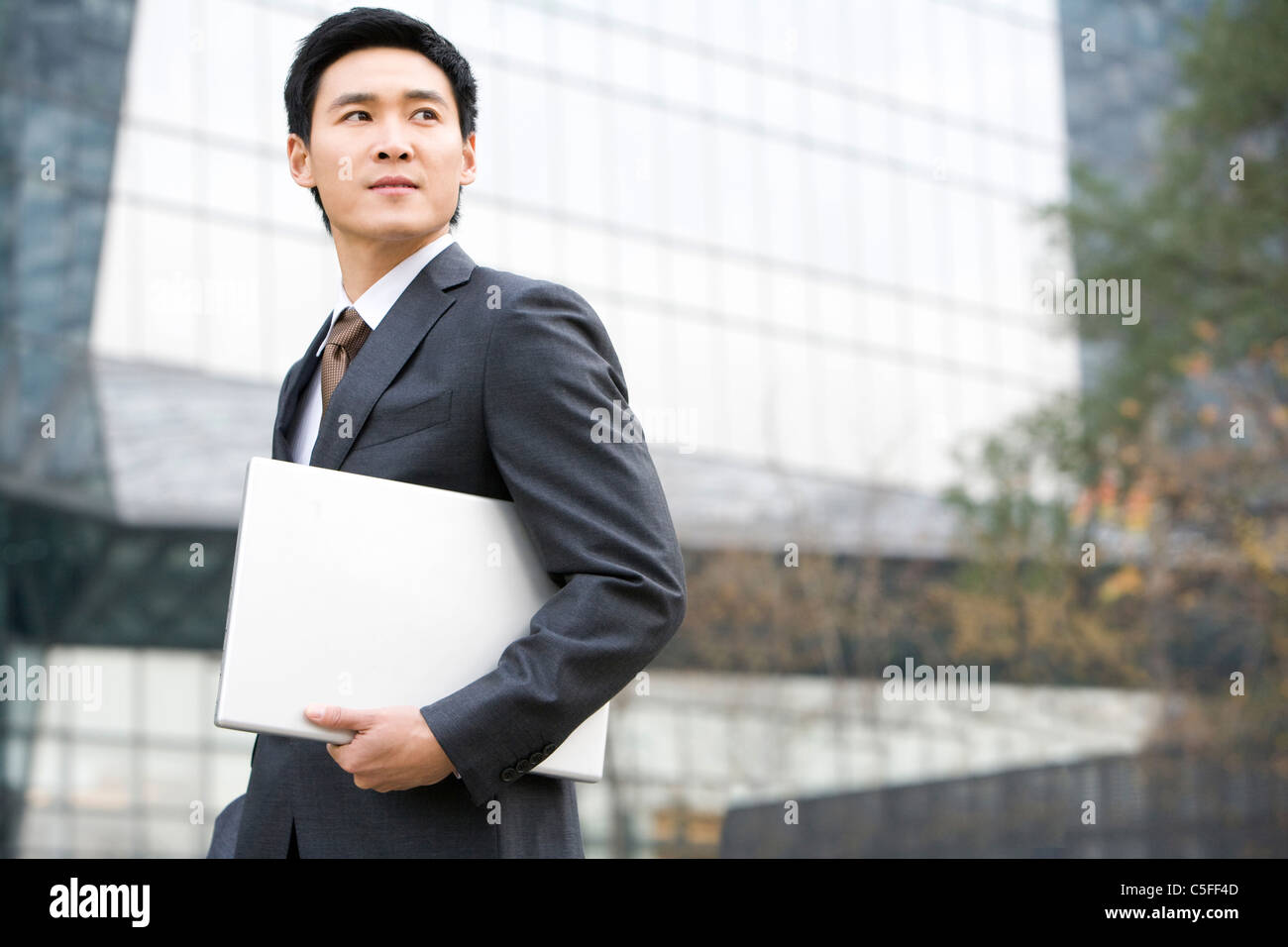 Businessman holding laptop Stock Photo - Alamy