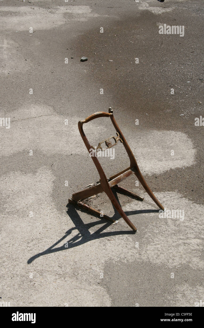 one damaged broken wooden chair on derelict ground Stock Photo - Alamy
