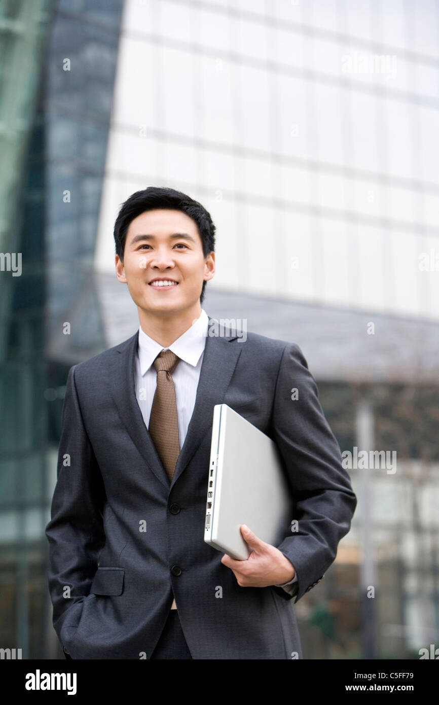 Businessman holding laptop Stock Photo - Alamy