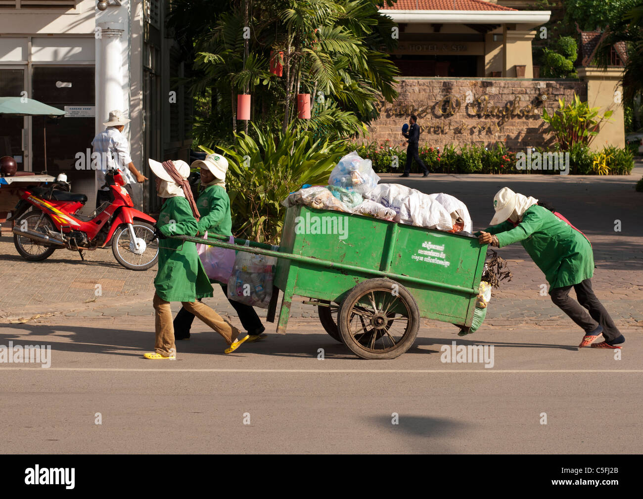 Rubbish collectors pulling and pushing a trash cart on Sivatha ...