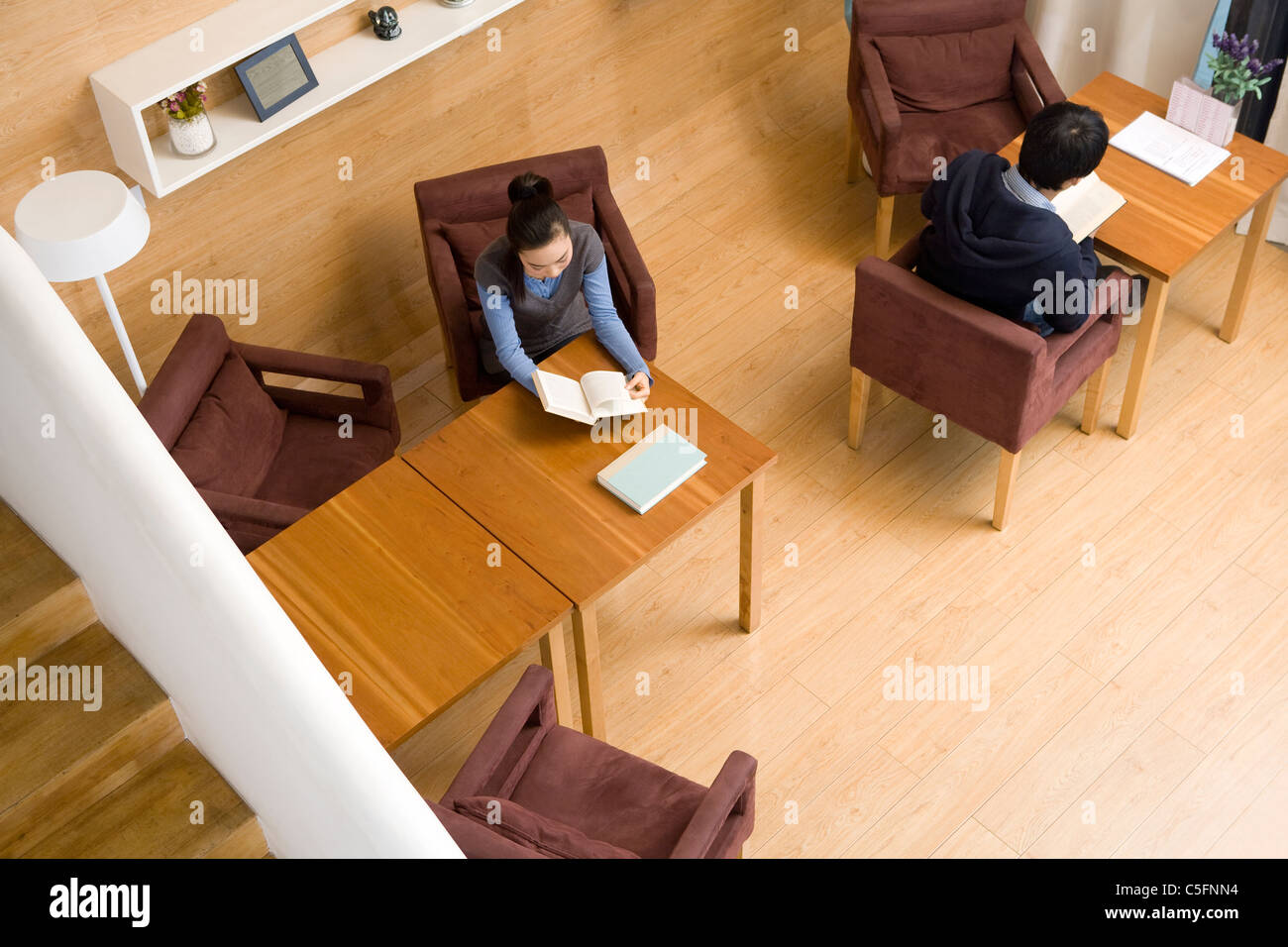 Two people reading books at a coffee shop Stock Photo - Alamy