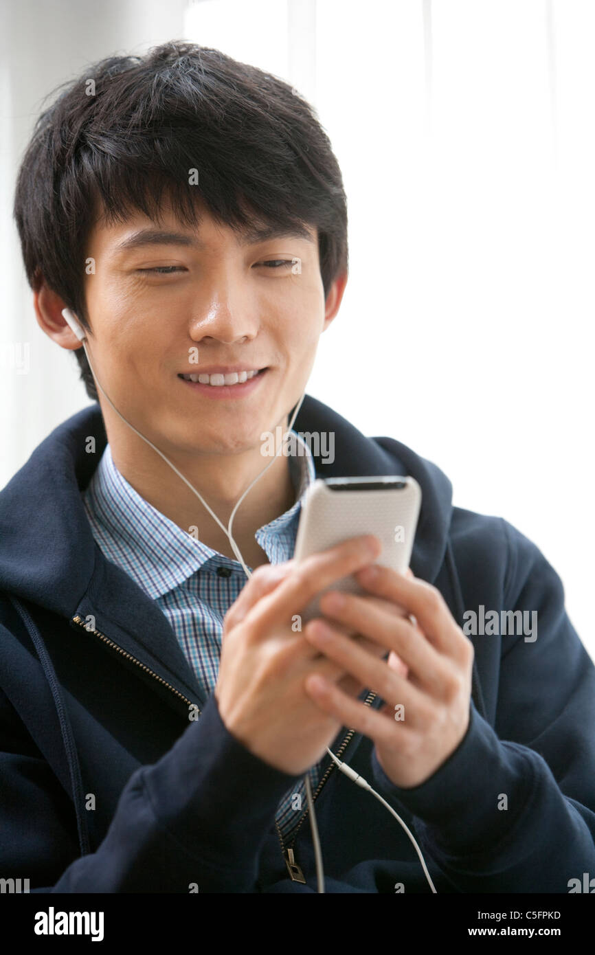A young man listening to mp3 player Stock Photo - Alamy
