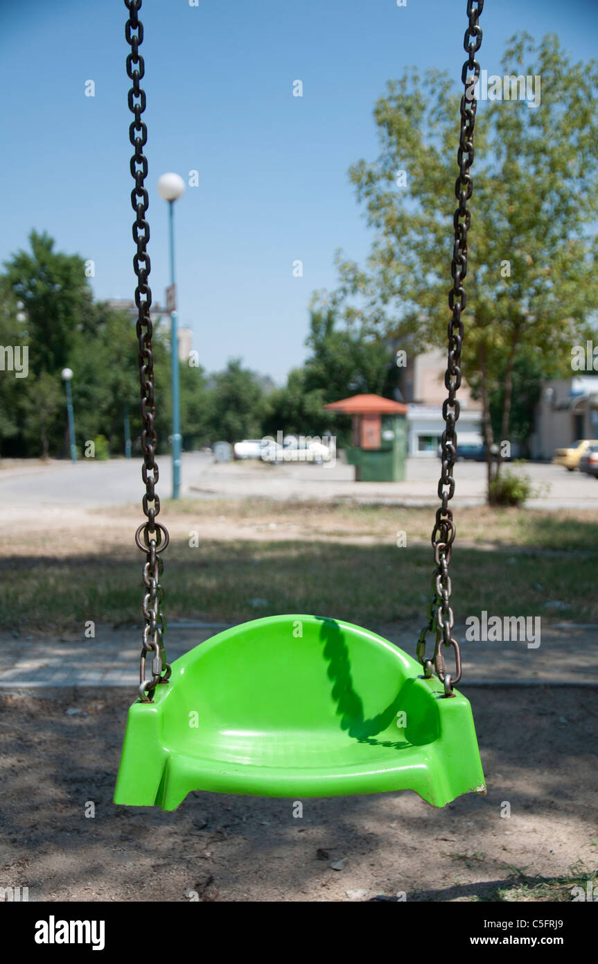 Empty green swing with chain. Vertical image Stock Photo - Alamy