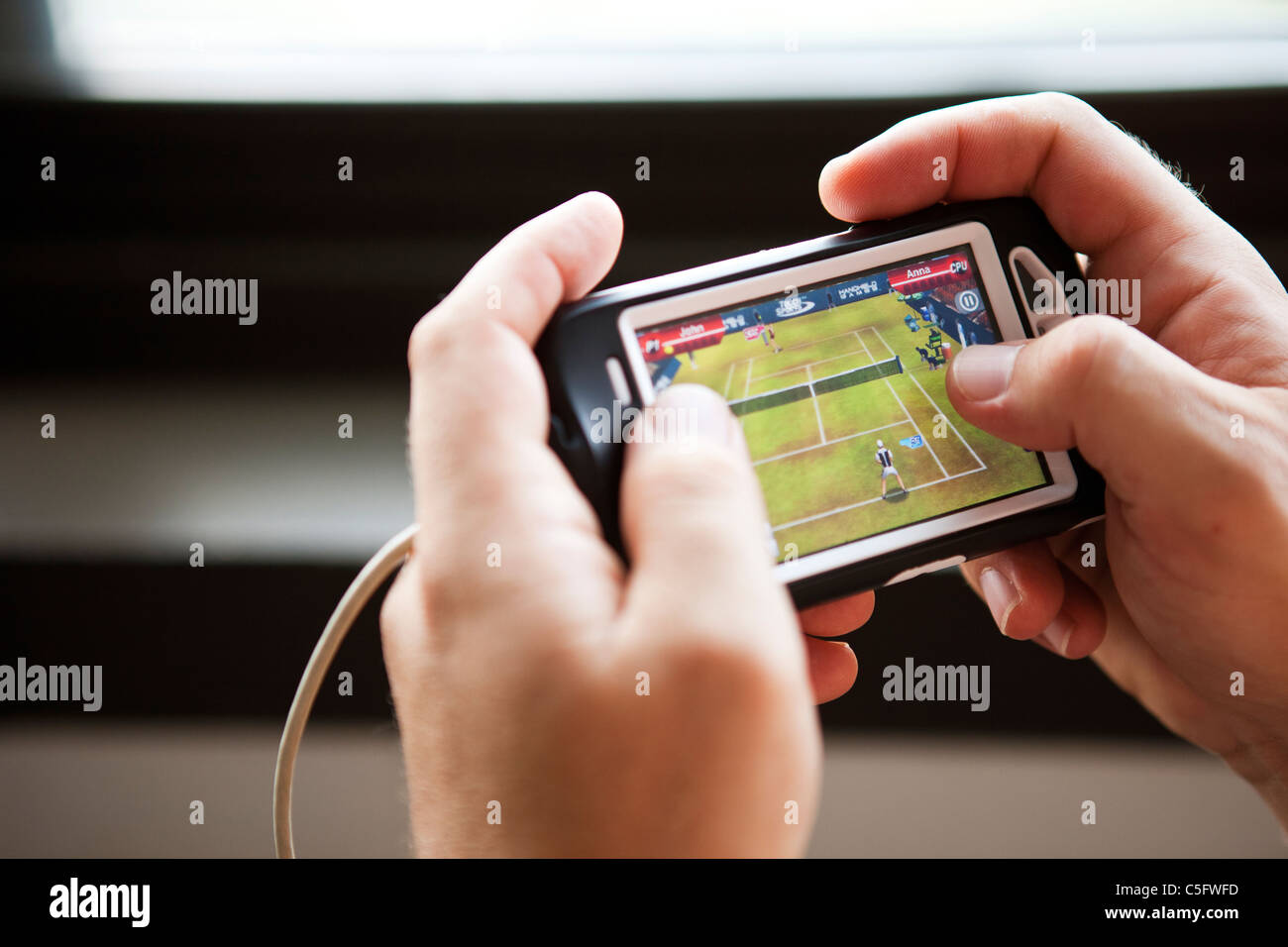 man playing game on iphone Stock Photo - Alamy
