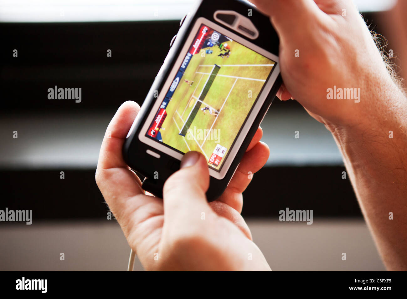 man playing game on iphone Stock Photo - Alamy